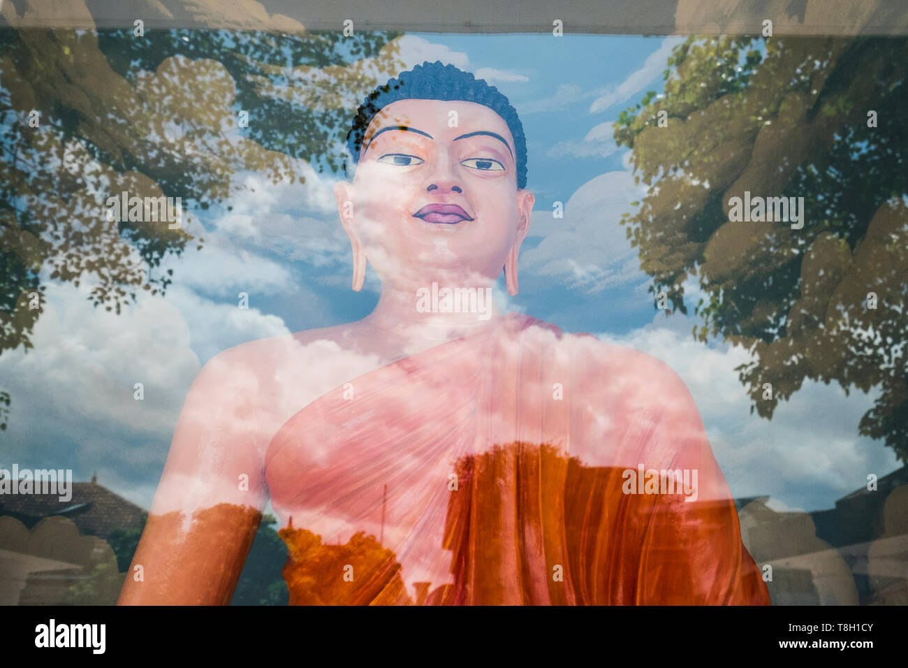 A beautiful Buddha statue caught in a nice sky and cloud reflection in ...