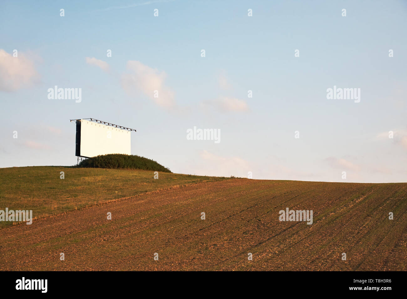 blank billboard on a hill behind a field. Free banner outdoors Stock ...