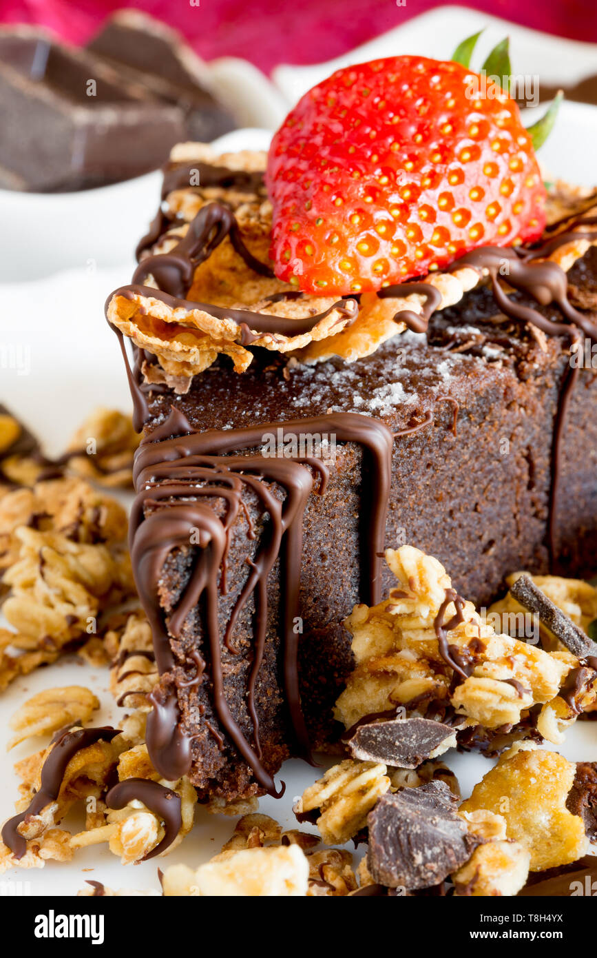 slice of chocolate cake with muesli, cereal and strawberries covered ...