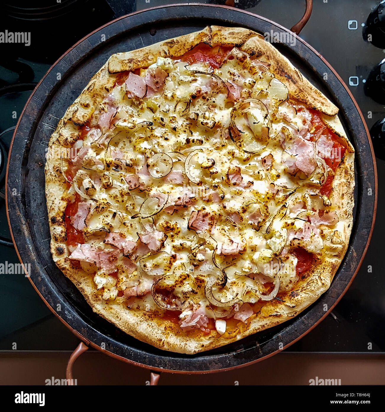 Homemade ham and onion pizza on a pizza stone Stock Photo - Alamy
