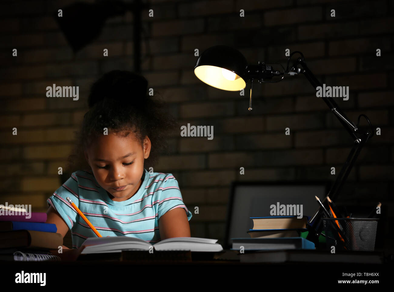 Little African-American girl doing homework in evening at home Stock ...