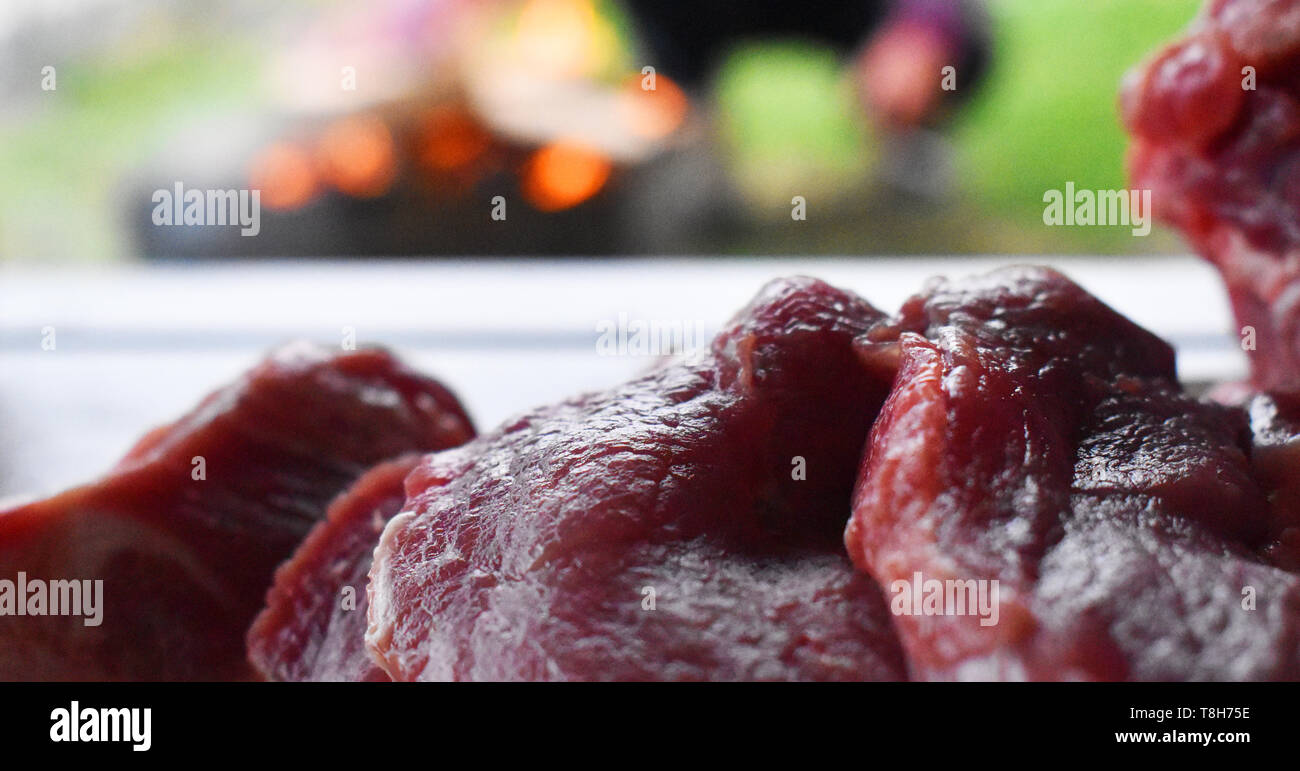 Fresh uncooked red meat on the wooden table ready to be cooked on the ...