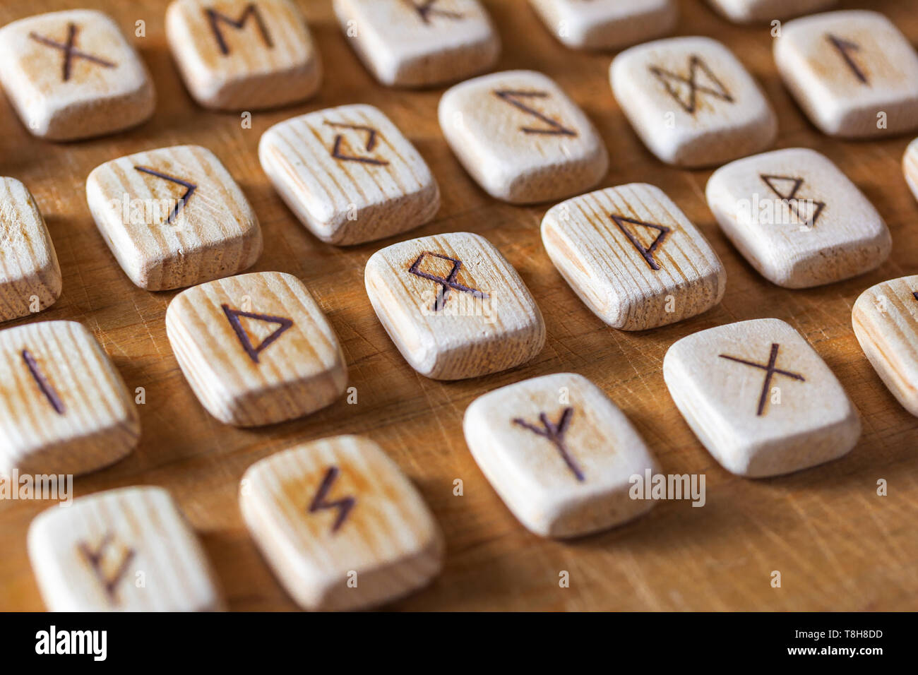 Anglo-saxon wooden handmade runes on the vintage table On each rune ...