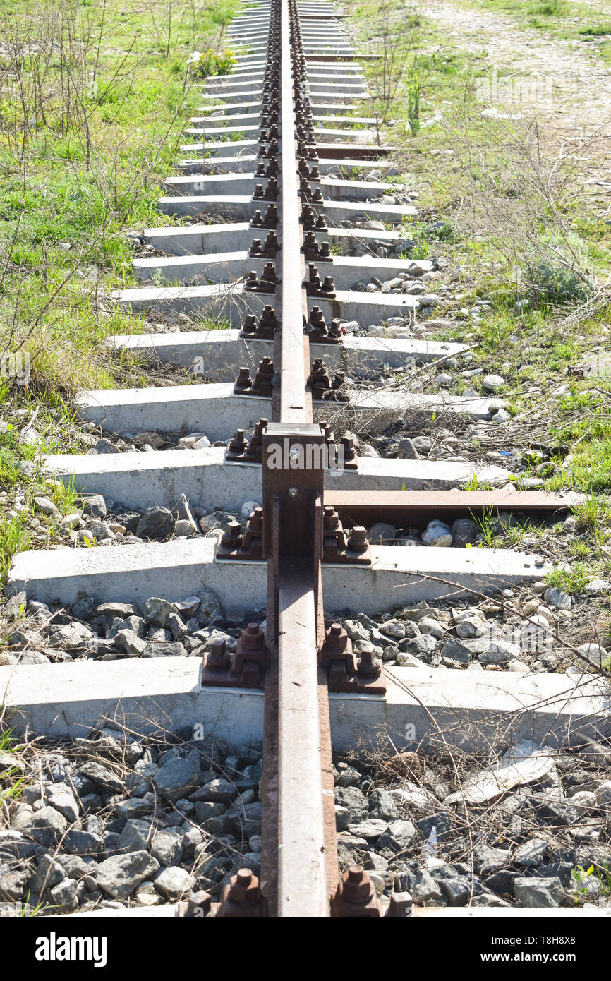 Single rusty rail going to the minerals mine Stock Photo - Alamy