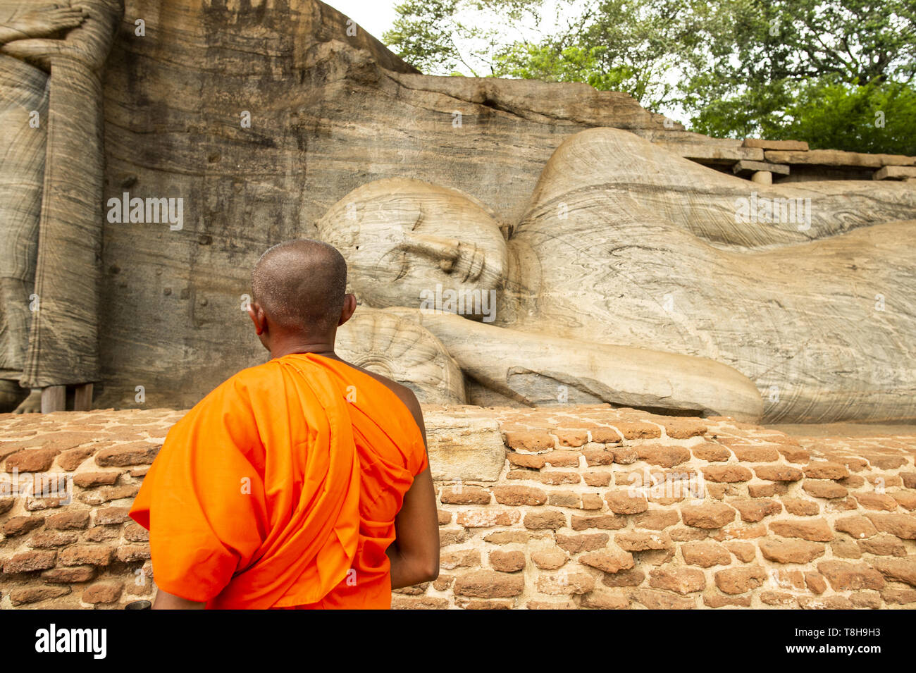 A monk is admiring the statue of the Reclining Buddha and Monk Ananda ...
