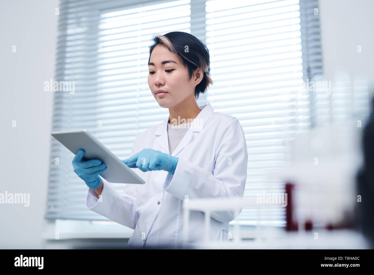 Busy Asian laboratory specialist working with data Stock Photo - Alamy