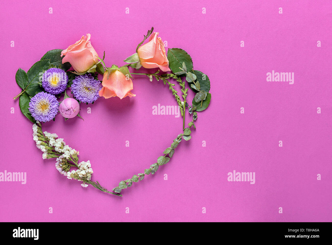 Heart made of beautiful flowers and leaves on color background Stock ...