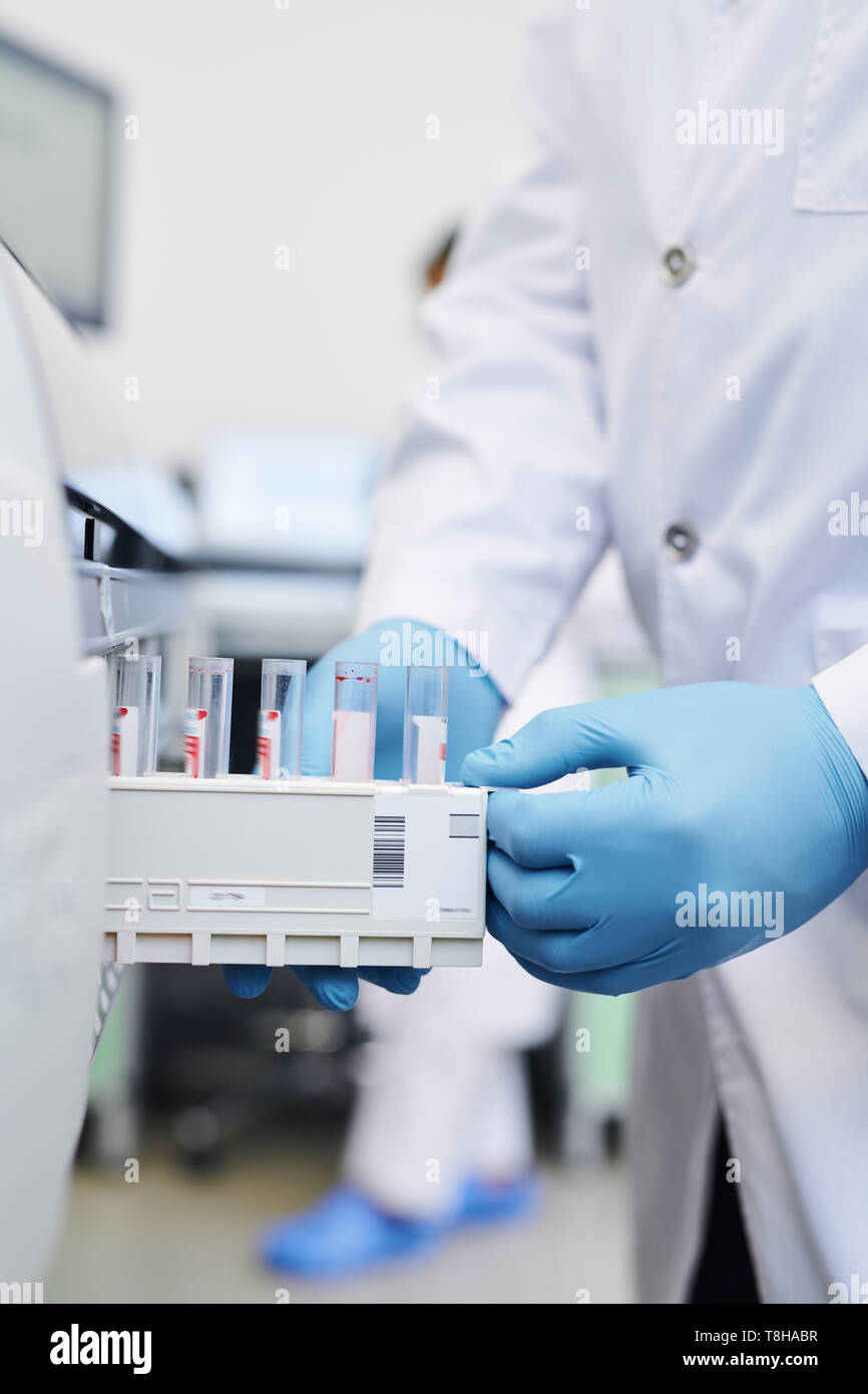 Putting test tube section into modern medical machine Stock Photo - Alamy