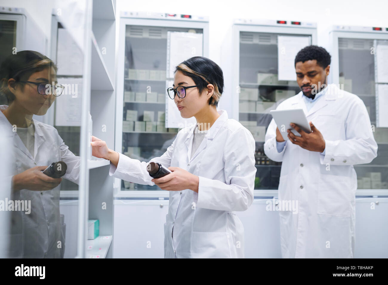 Asian pharmacist sorting medications in storage room Stock Photo - Alamy