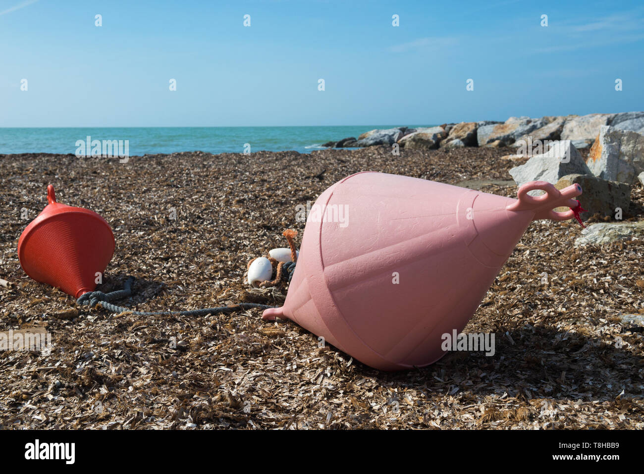 Two big buoys on the beach, azure sea and the rocky beach Stock Photo ...