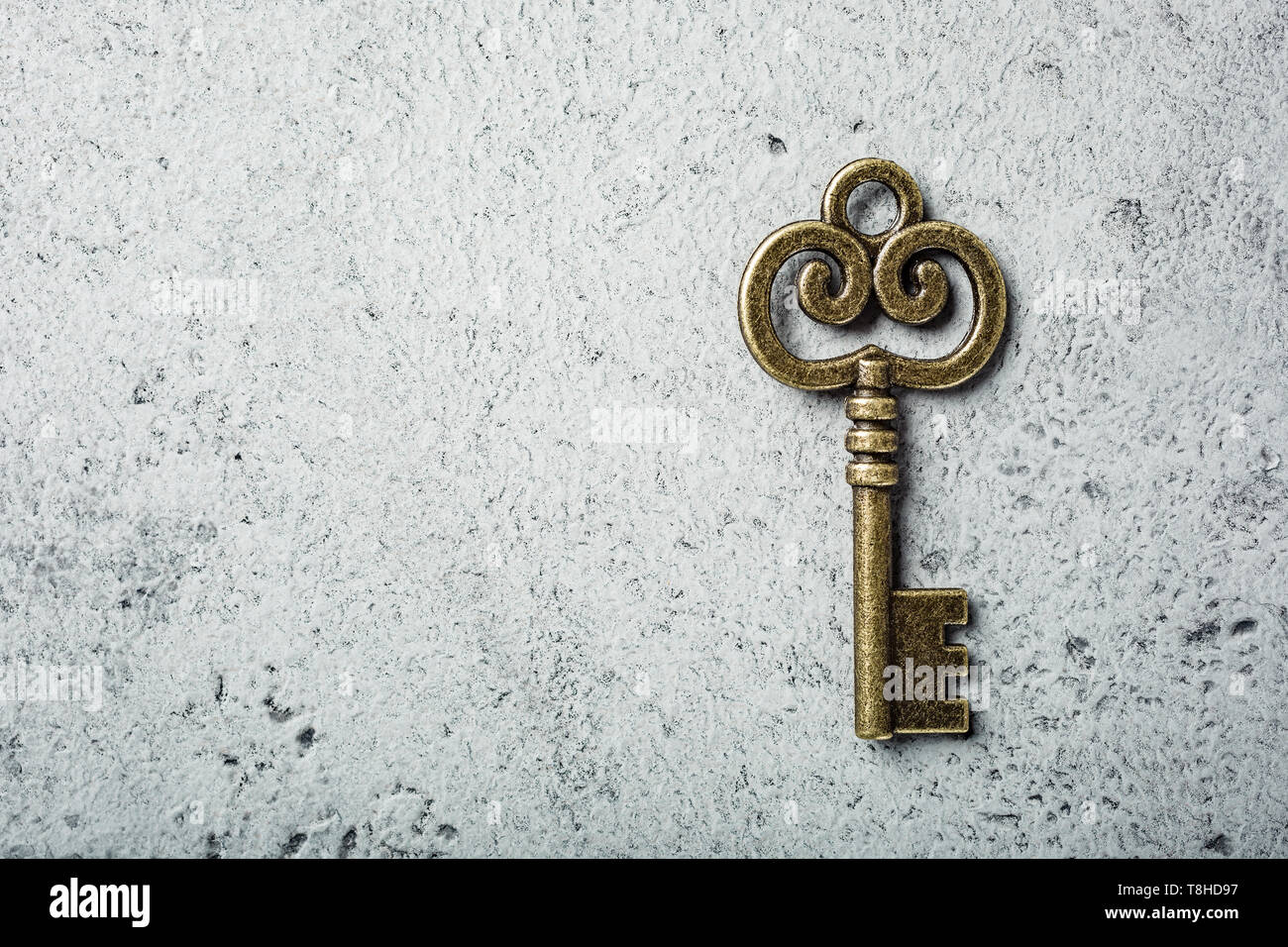 Old key on old gray concrete background Stock Photo - Alamy
