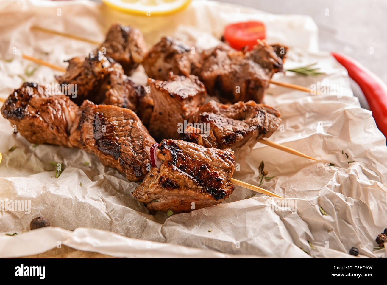 Skewers with delicious shish kebab on parchment paper, closeup Stock ...
