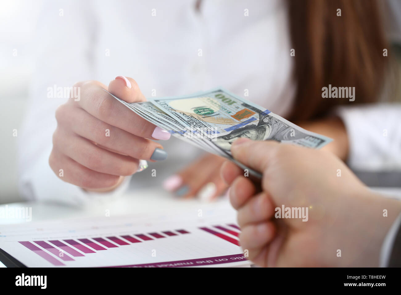 Male arm pay bunch of hundred dollars bills to office clerk closeup ...