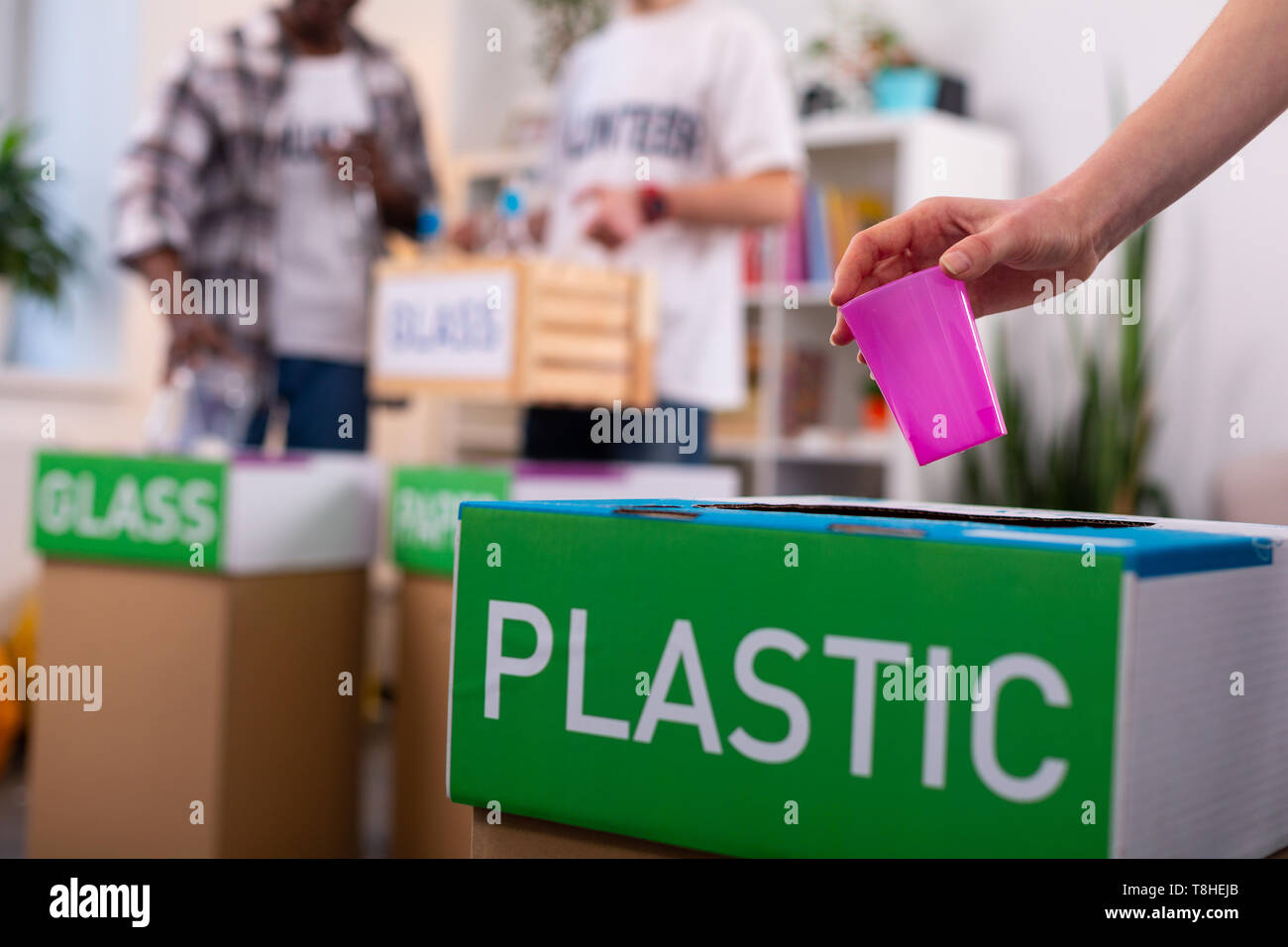 Girl putting plastic into box sorting litter in ecology organization ...