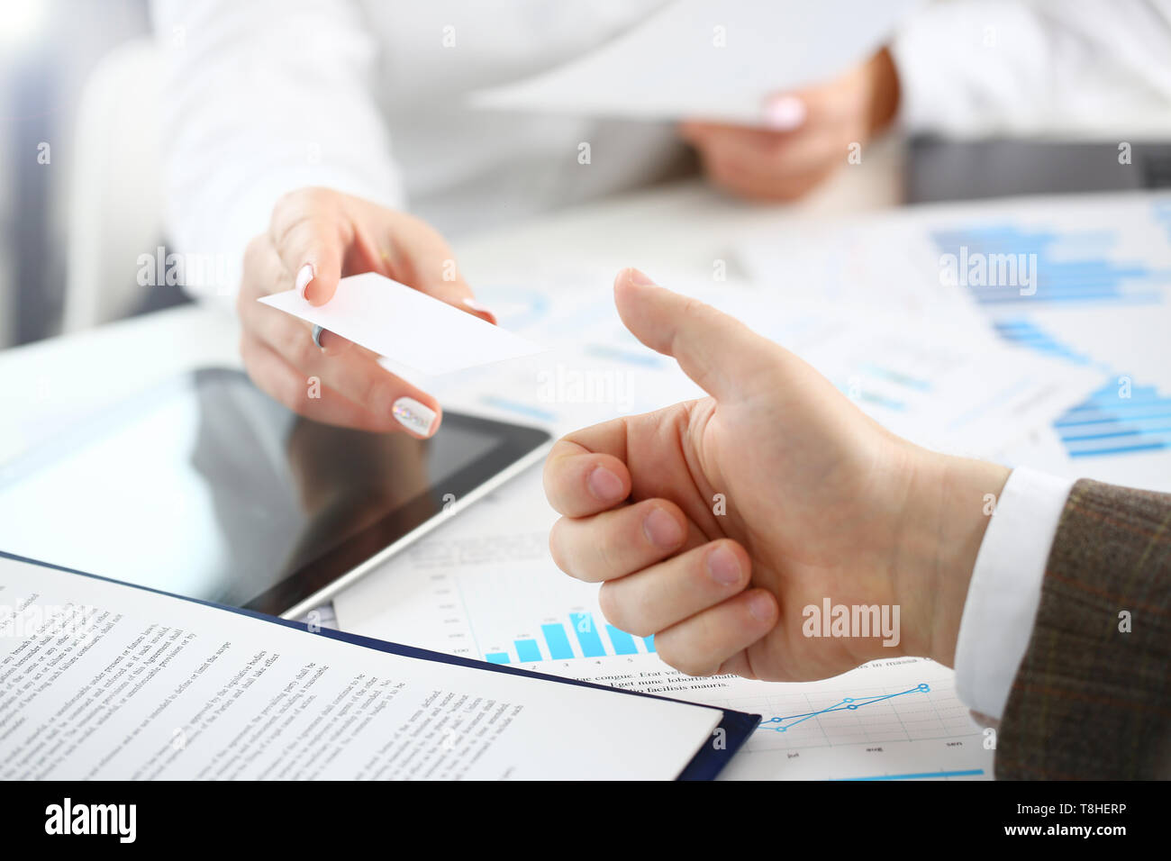 Female arm in suit give blank calling card to visitor closeup. White ...