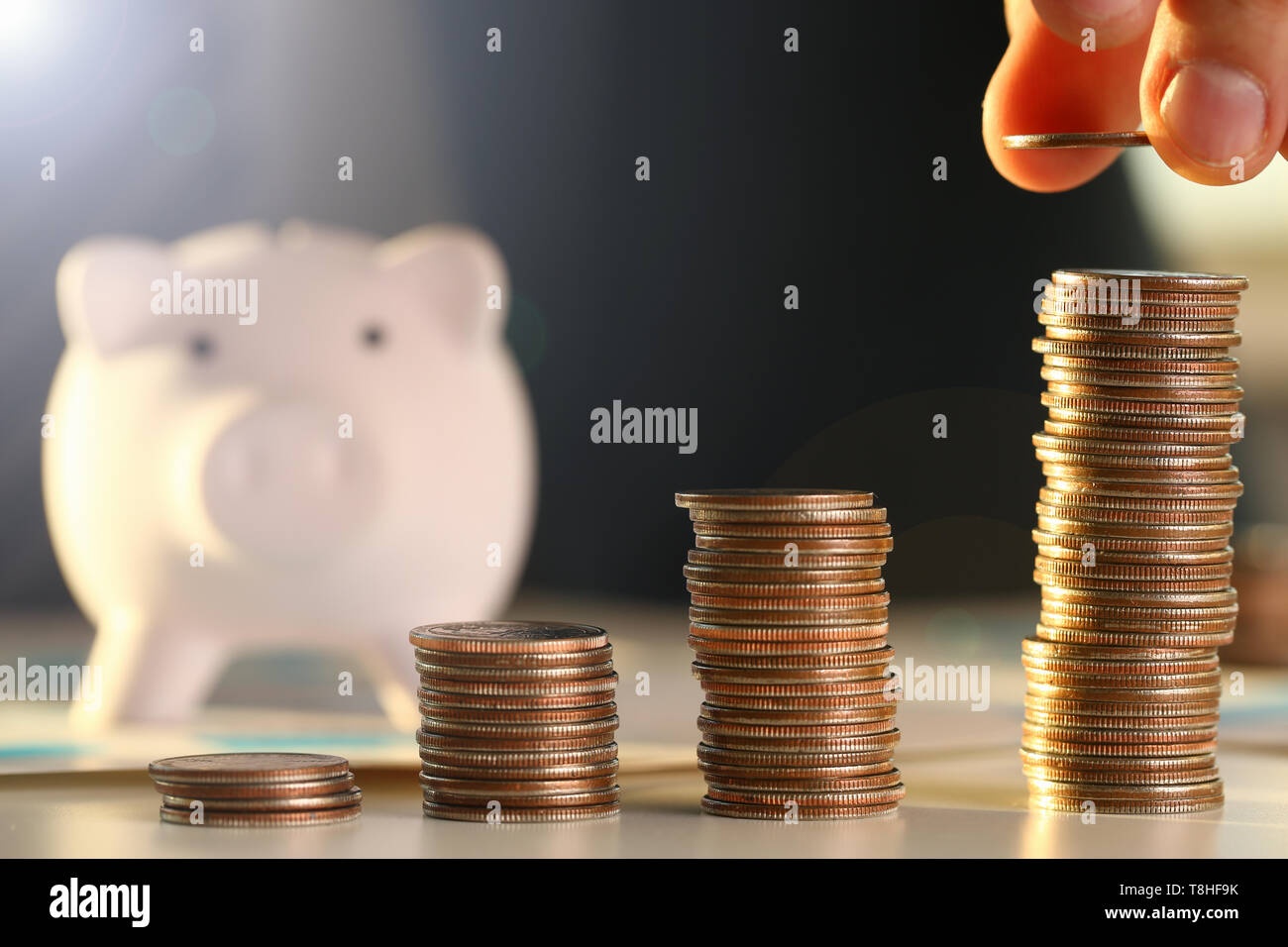 Hand businessman putting pin money into pig Stock Photo - Alamy