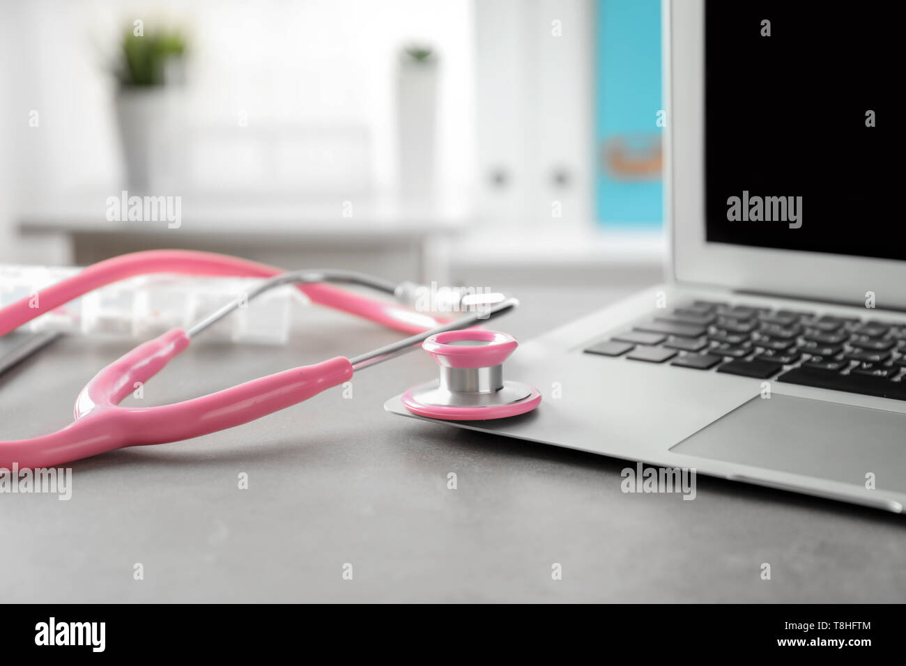 Medical stethoscope and laptop on grey table Stock Photo - Alamy
