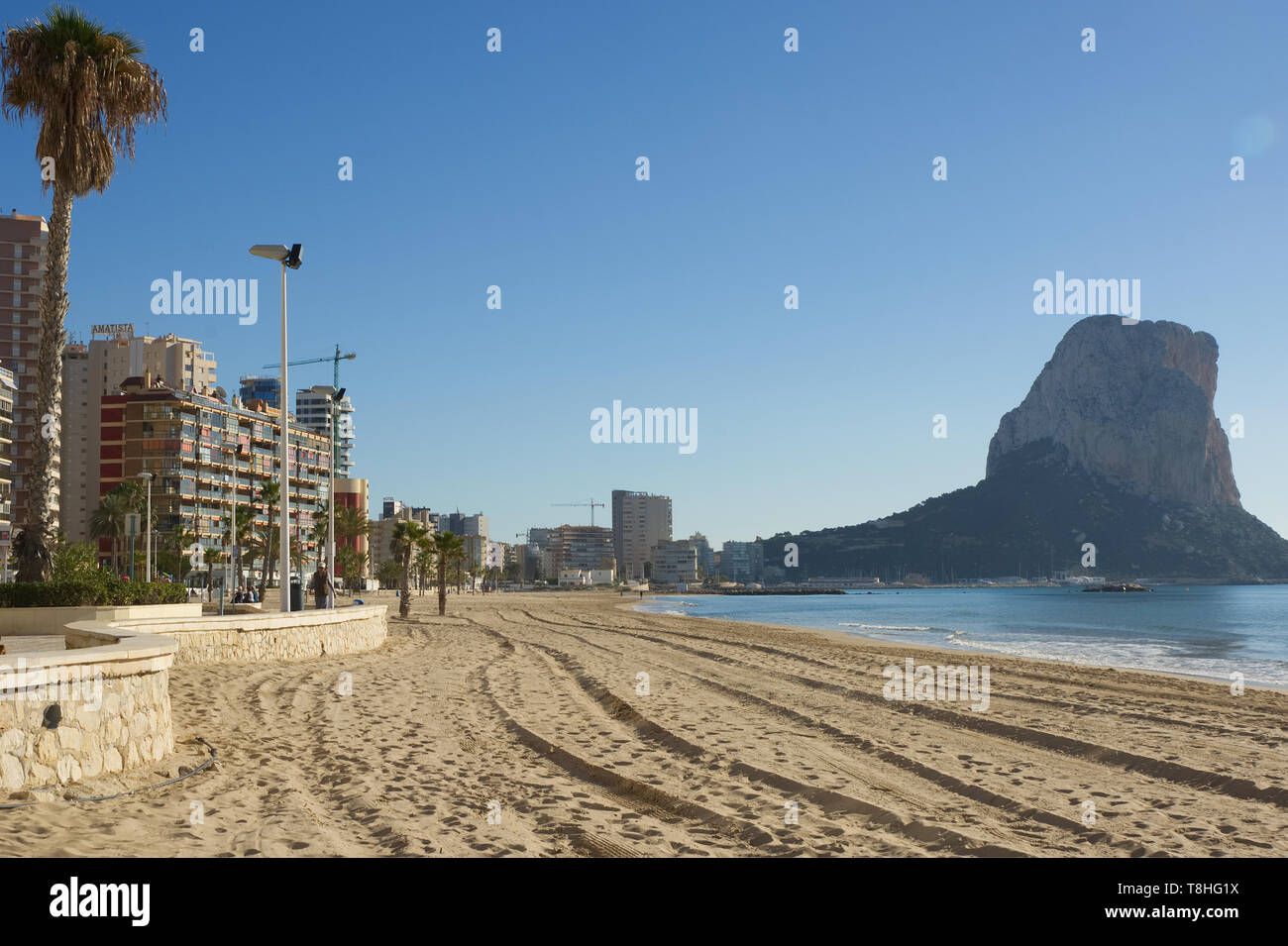 Beach and seafront promenade at Calpe, Spain. Penon de Ifach in ...
