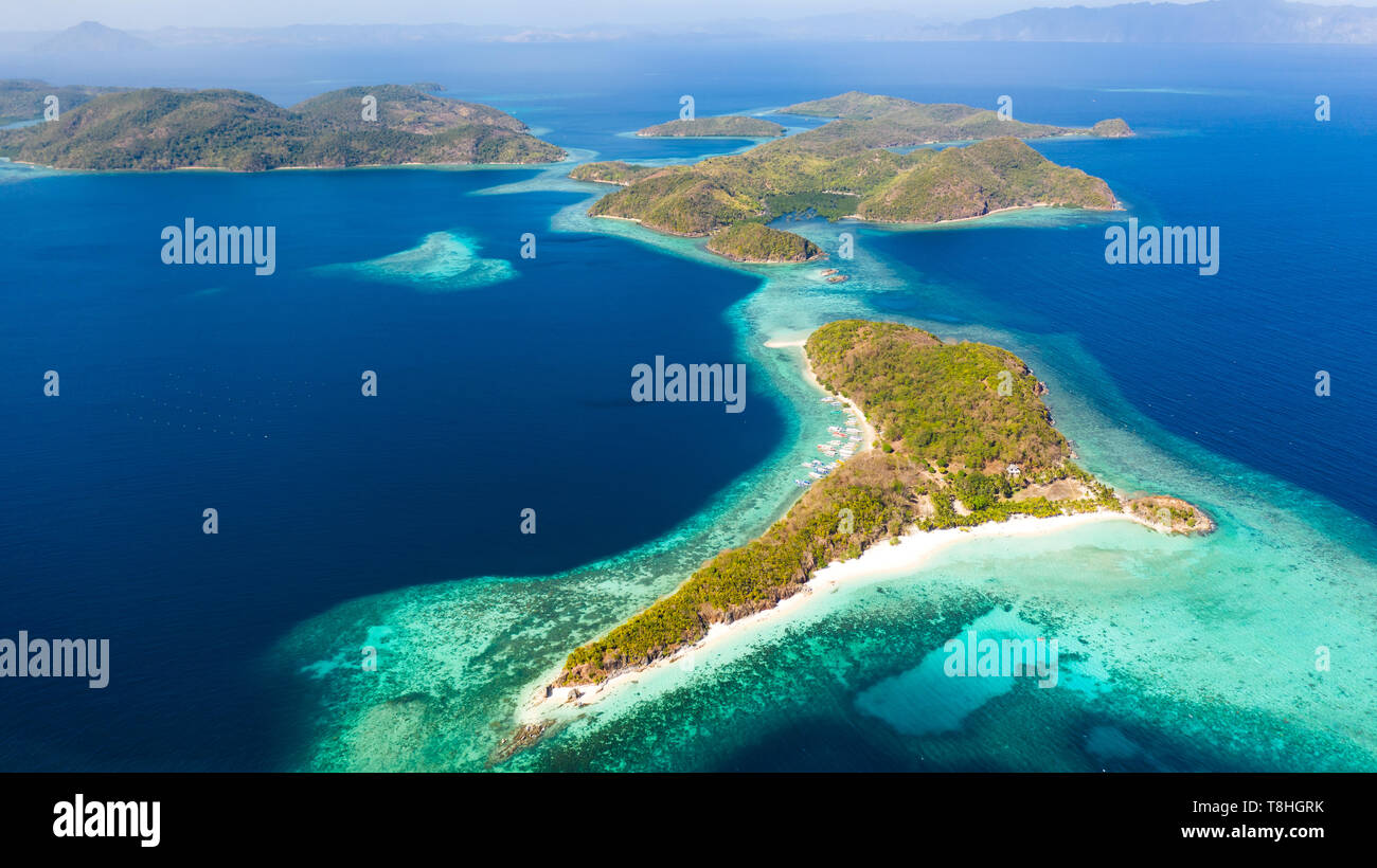 An island with a sandy beach and a coral reef.Philippine islands with ...