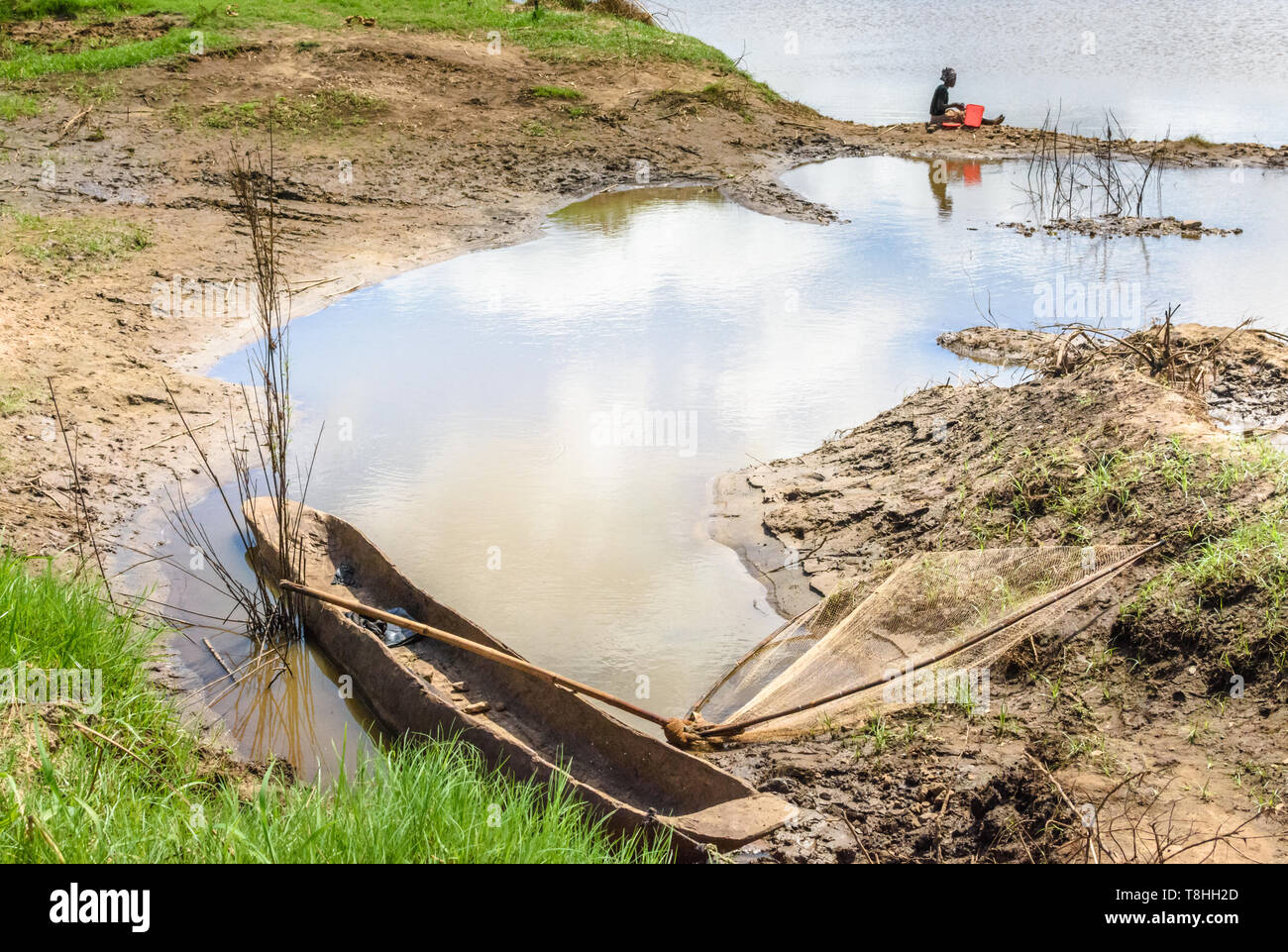 a fishing canoe and fishing net left abandoned in a small creek off the ...