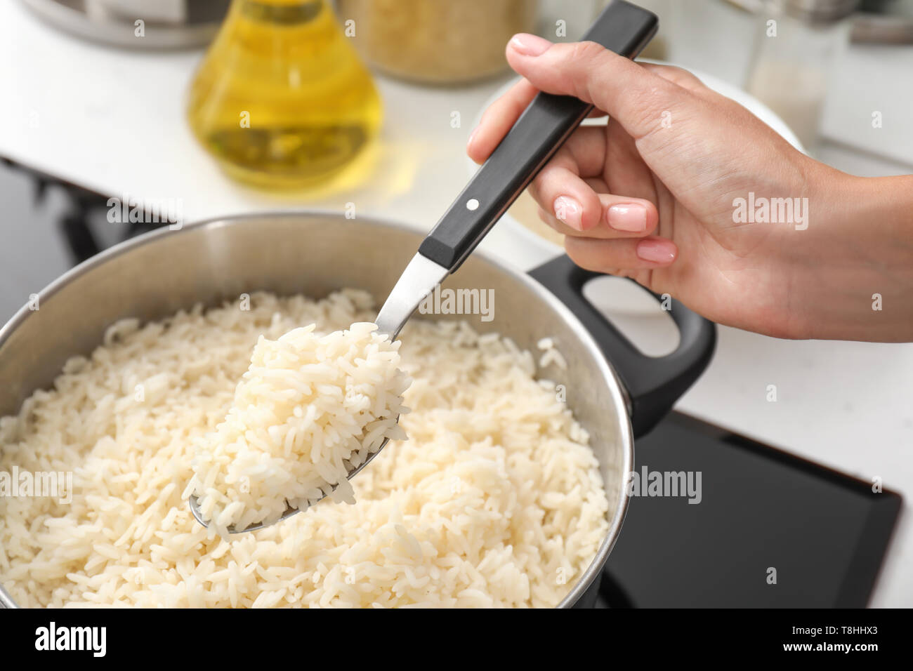 Woman cooking rice on stove in kitchen, closeup Stock Photo - Alamy