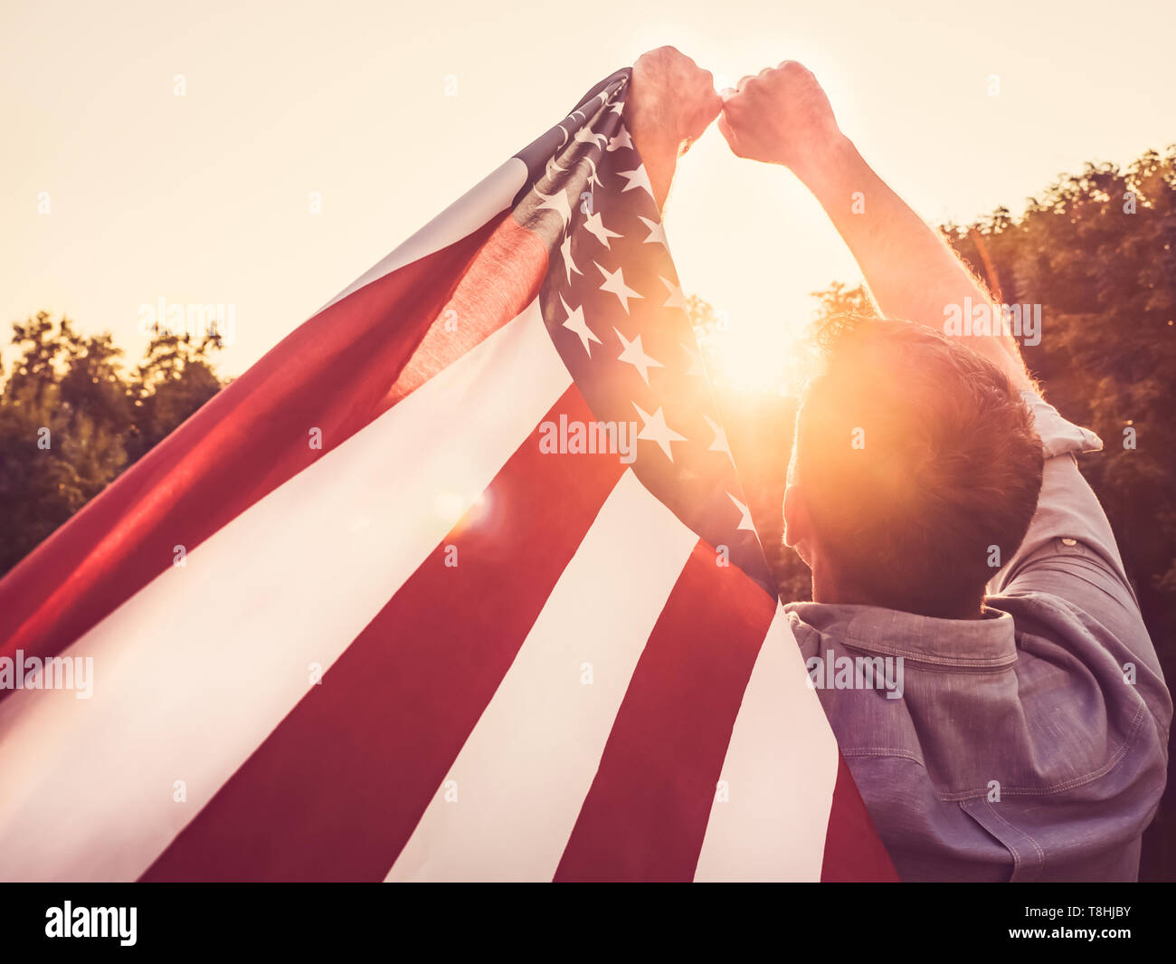 Handsome, young man waving an American flag Stock Photo - Alamy