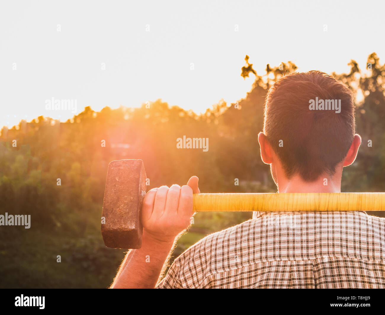 Man holding a sledgehammer in his hands Stock Photo - Alamy