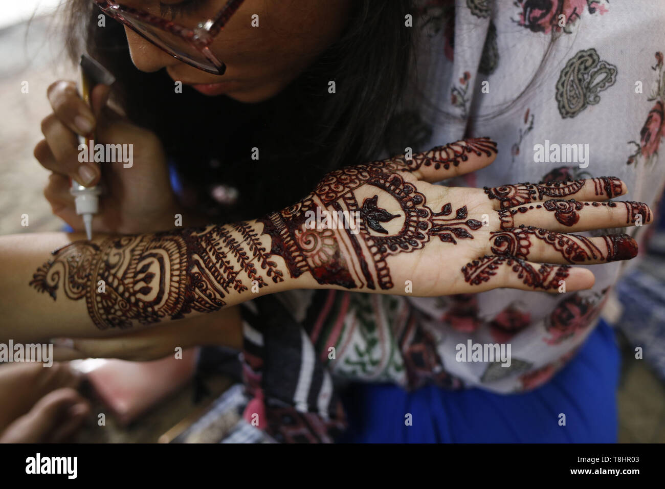 Dhaka, Bangladesh. 13th May, 2019. An artisan applies henna on the hand ...