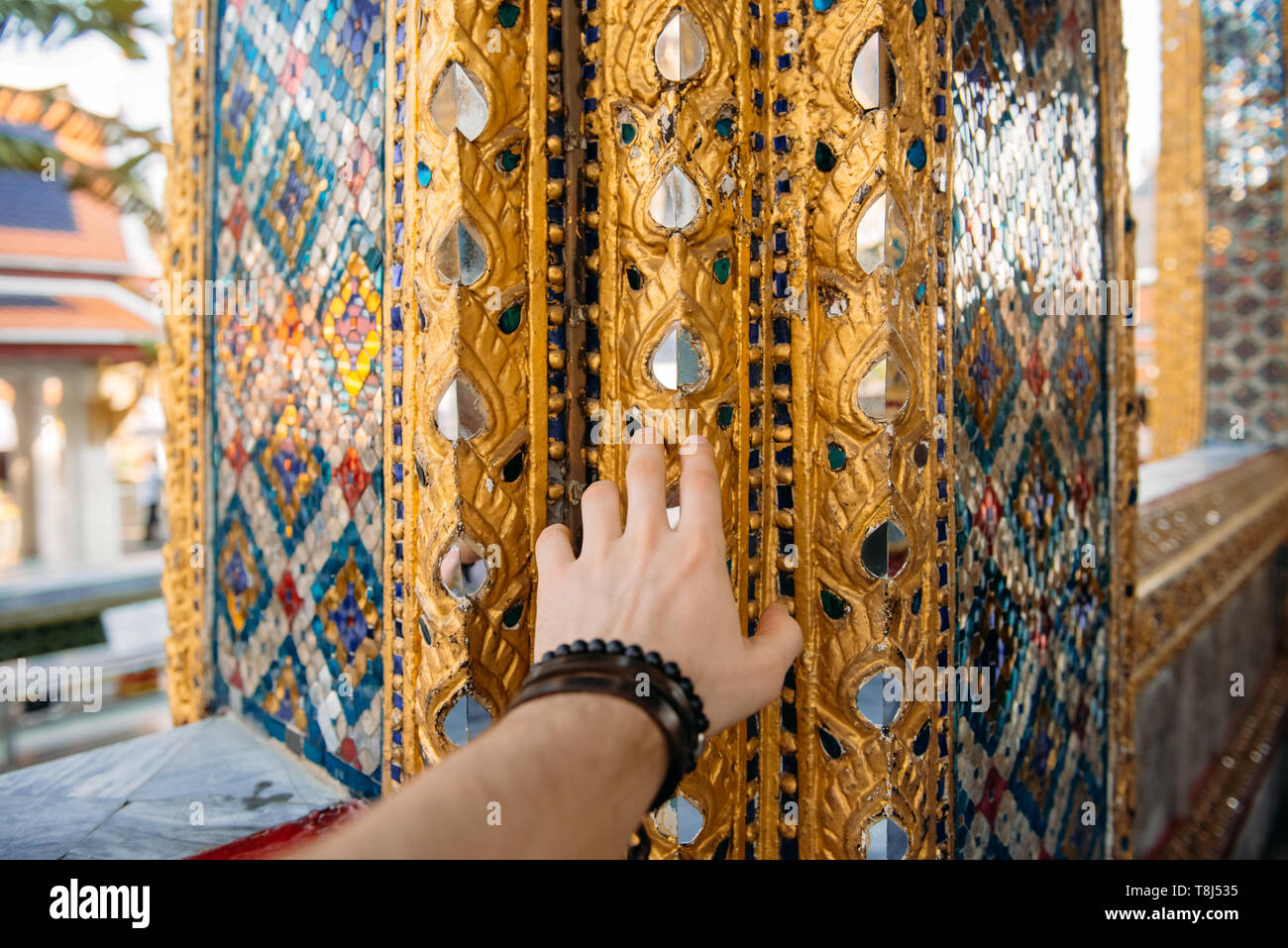 Hand touching an ornate wall, Golden Buddha, Temple of Wat Traimit ...