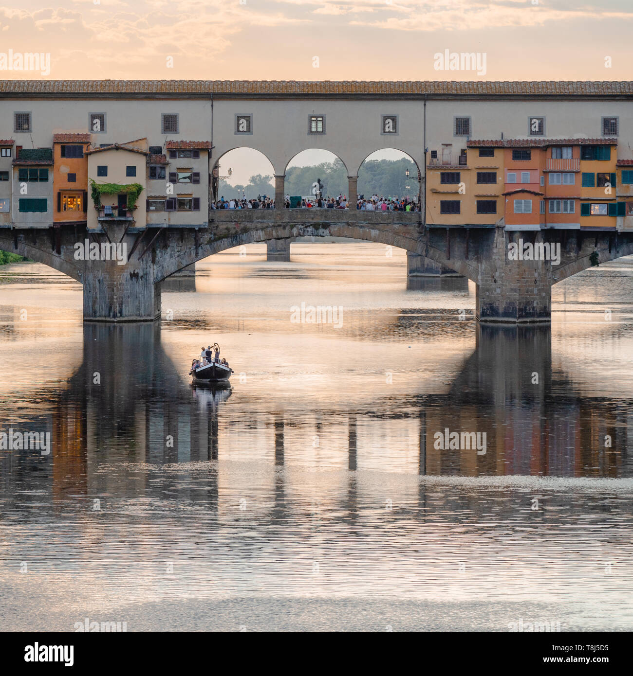 Bridge Ponte del Vecchio ("Old Bridge") over Arno river, boat under the ...