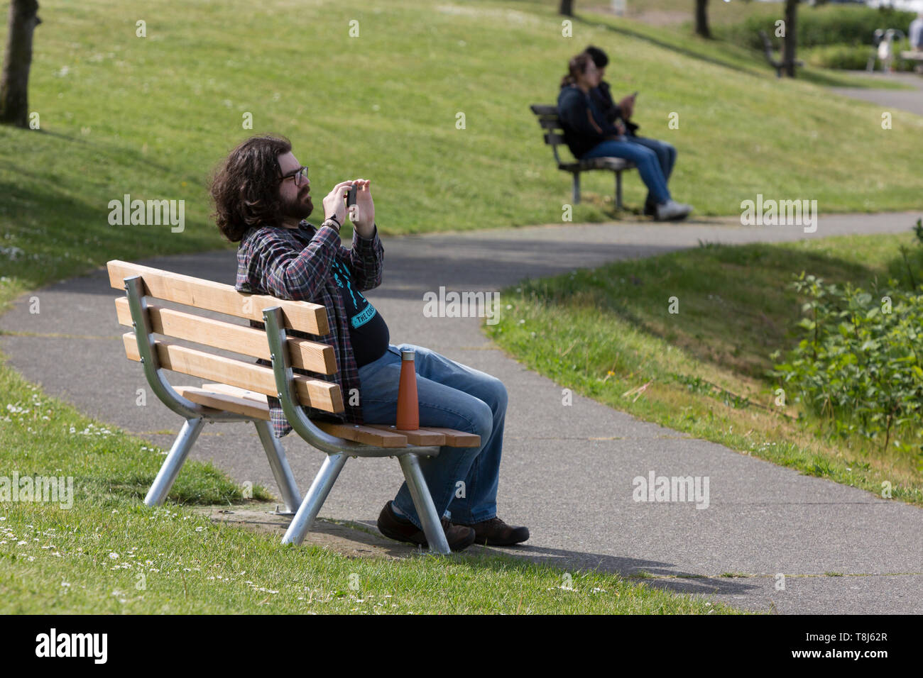 Seattle, Washington: A man takes a photo while relaxing in Seacrest ...