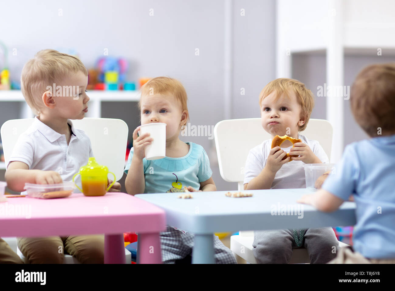 Group of children have breaktime to eat in daycare centre Stock Photo ...