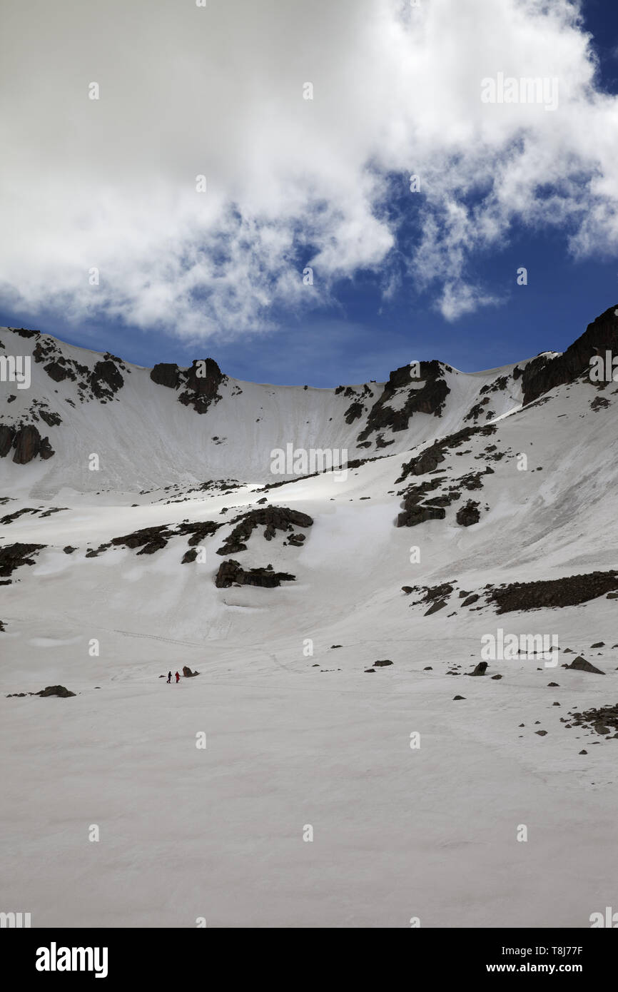 Snowy plateau, high mountain pass and blue sunlit sky with clouds at ...
