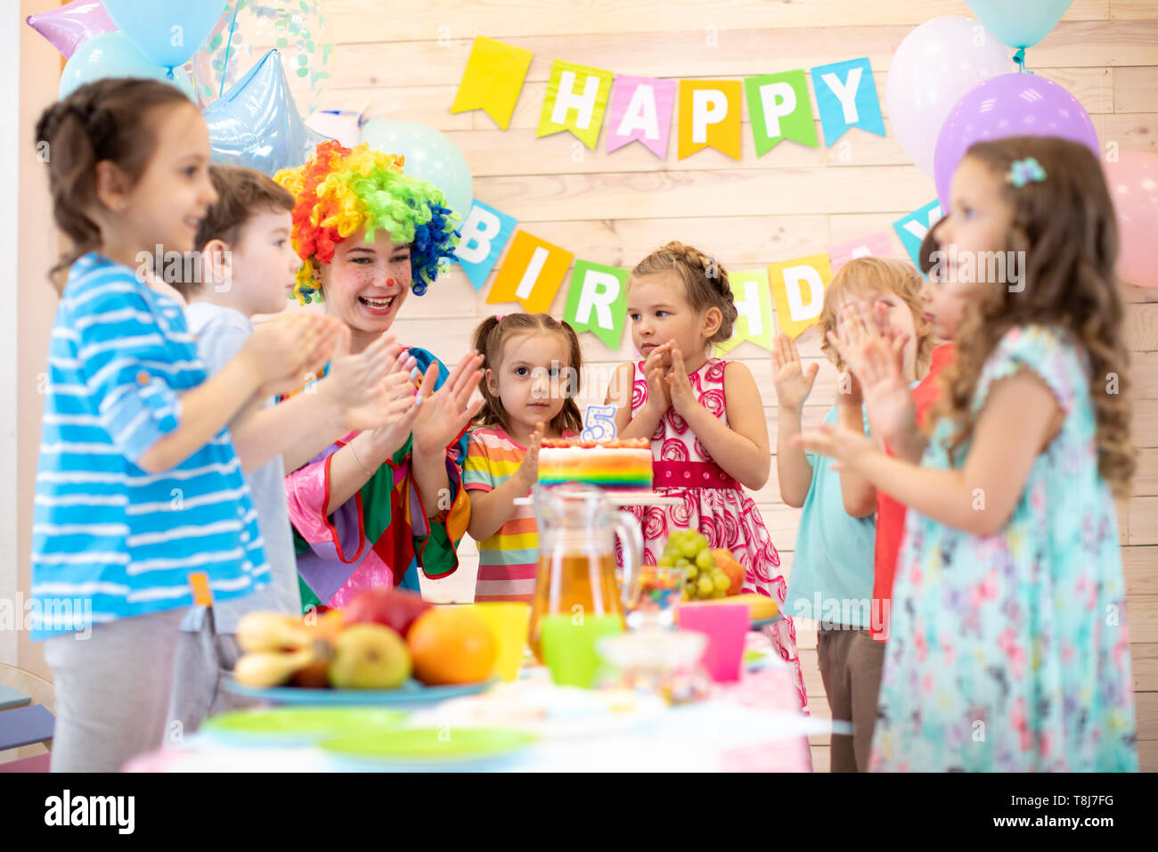 Childs are happy after they have blowed candles out on birthday party ...