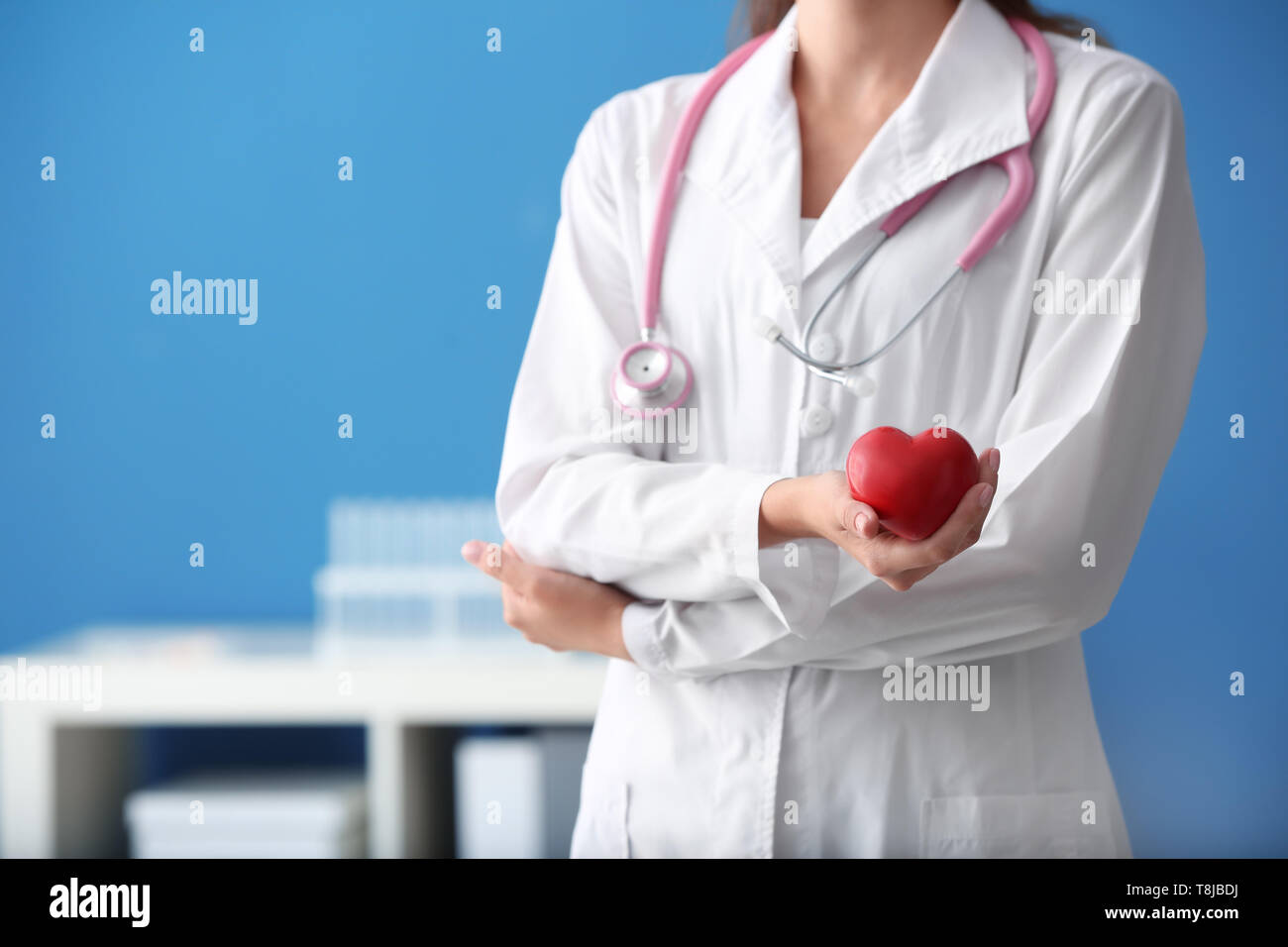 Cardiologist with red heart in clinic Stock Photo - Alamy