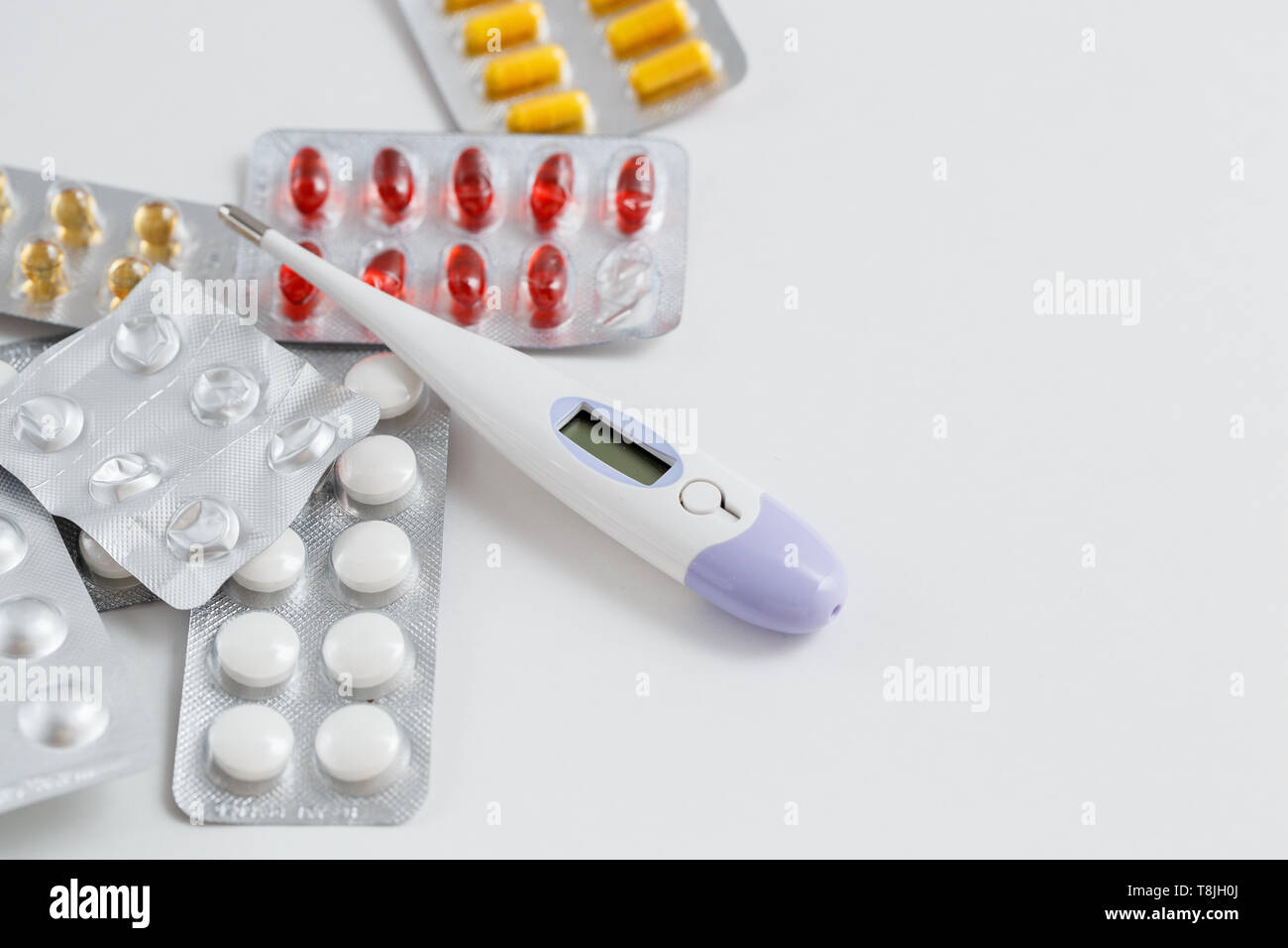 electronic thermometer and medicines on white isolated background Stock ...