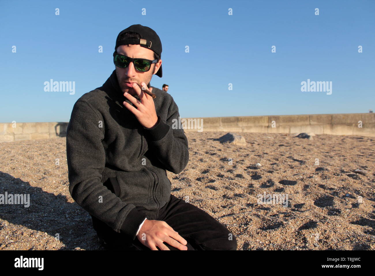 Guy smoking a cigar on the beach Stock Photo - Alamy