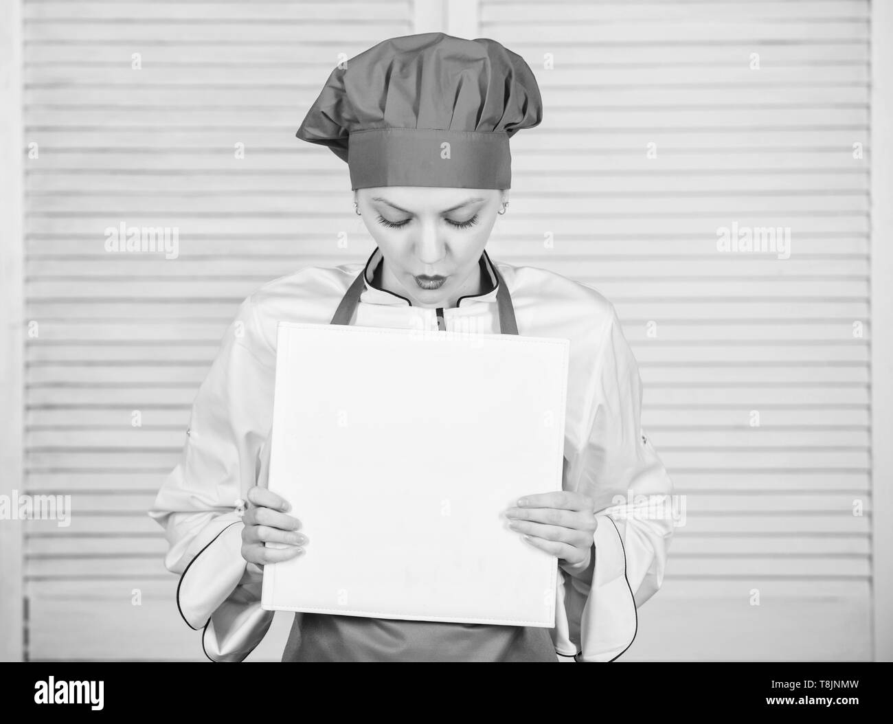 Woman chef cooking food. Culinary concept. Amateur cook read book ...