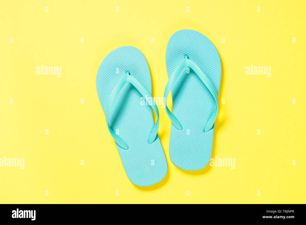 Blue flip flops on yellow background Stock Photo - Alamy