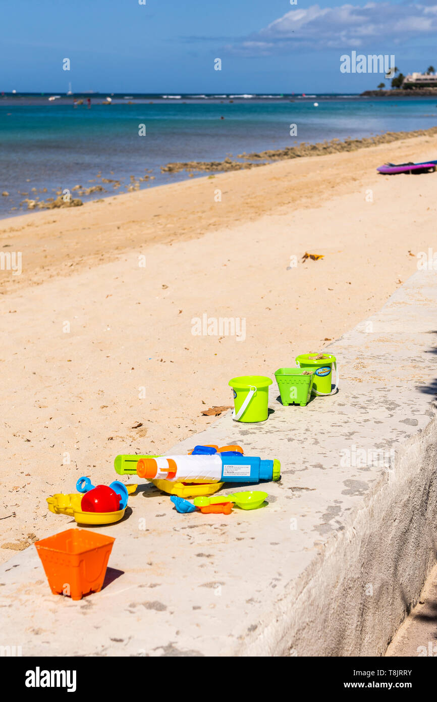 Children's toys scattered on a break water on the sand, Maui, Hawaii ...