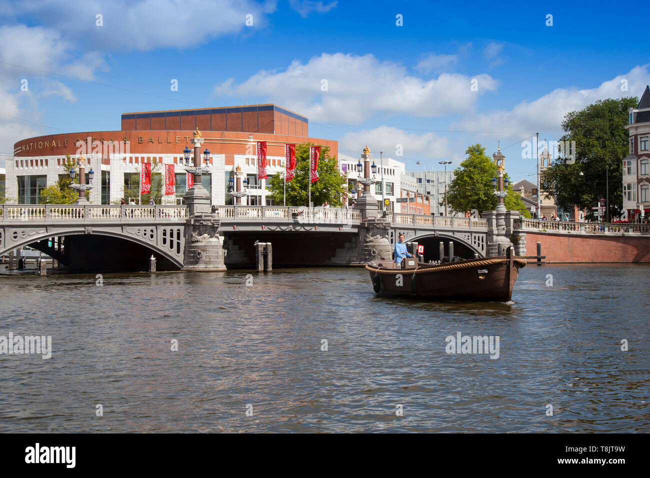 The opera house of Amsterdam, in the foreground a small canal boat on ...