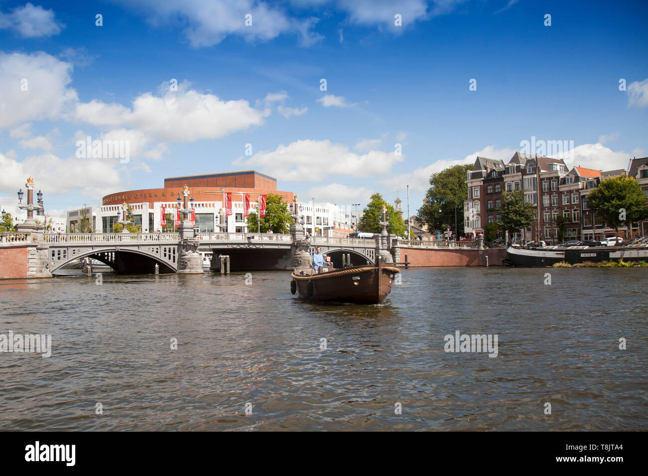 The opera house of Amsterdam, in the foreground a small canal boat on ...