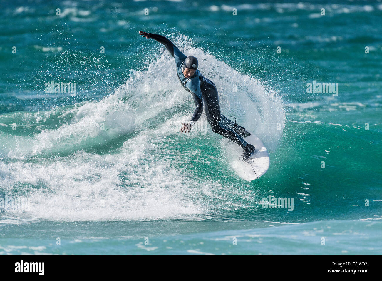 Surfing action as a surfer carves a wave at Fistral in Newquay in ...