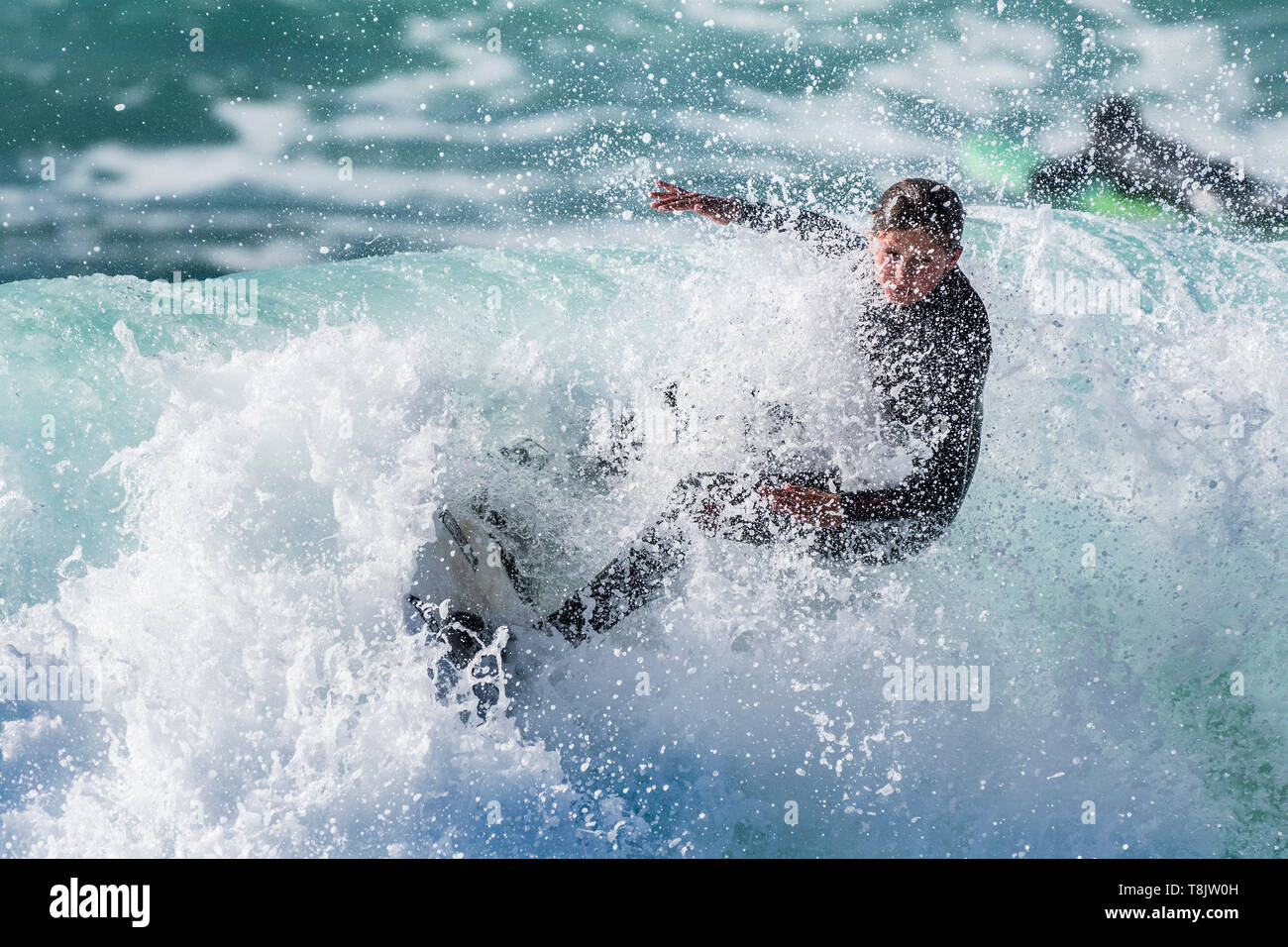 Spectacular surfing action as a young female surfer is covered in spray ...