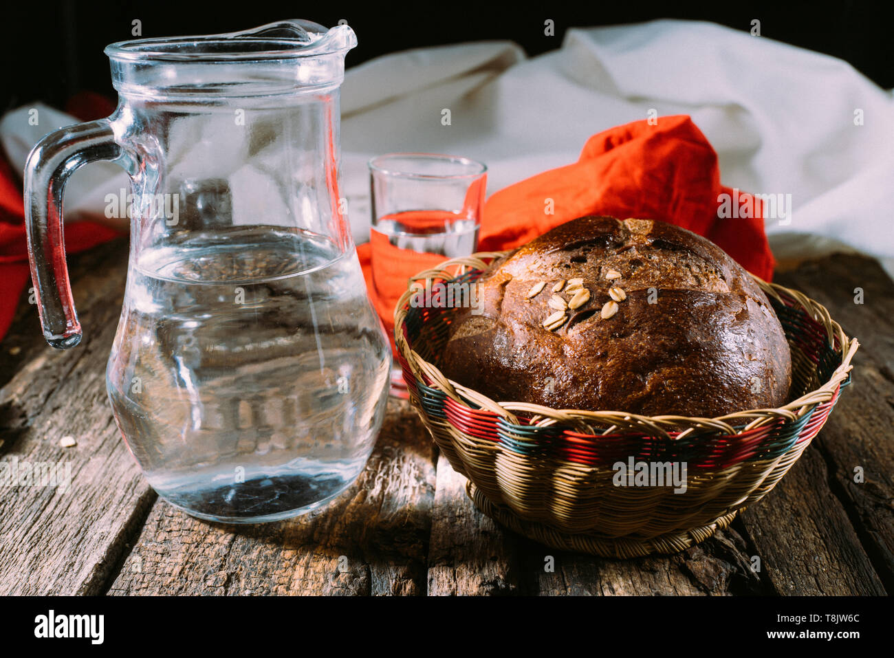 Homemade wholemeal bread in a wicker bread basket wrapped in red napkin ...