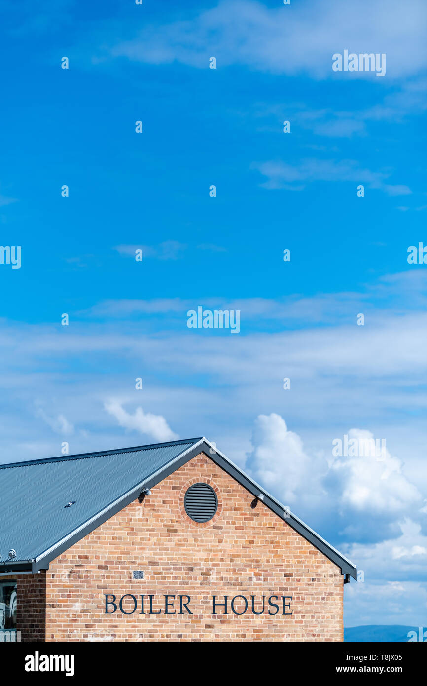 Top roof line of a boiler house building made of brick with blue sky ...
