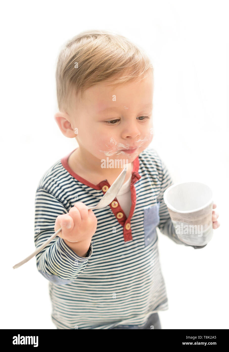 Little boy eating yogurt with strong appetite, having a funny messy ...