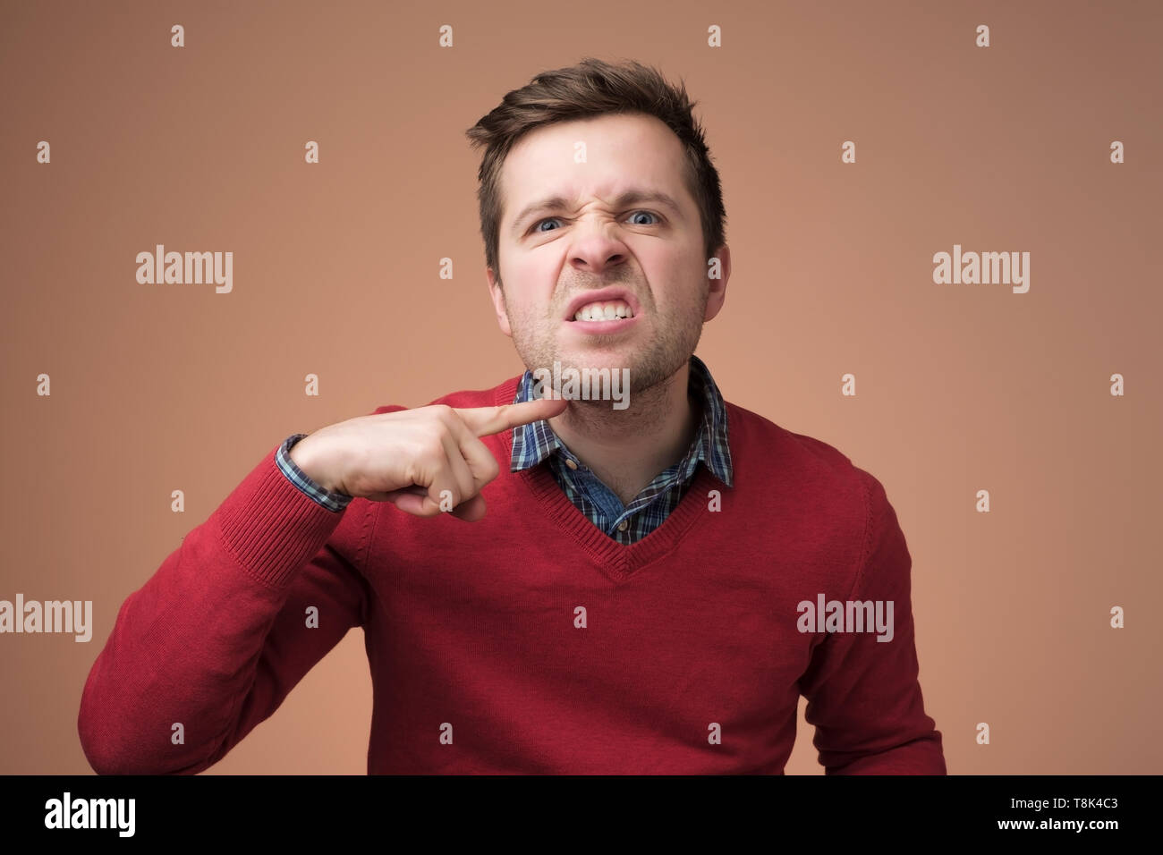 man gesturing with index finger at his neck Stock Photo - Alamy