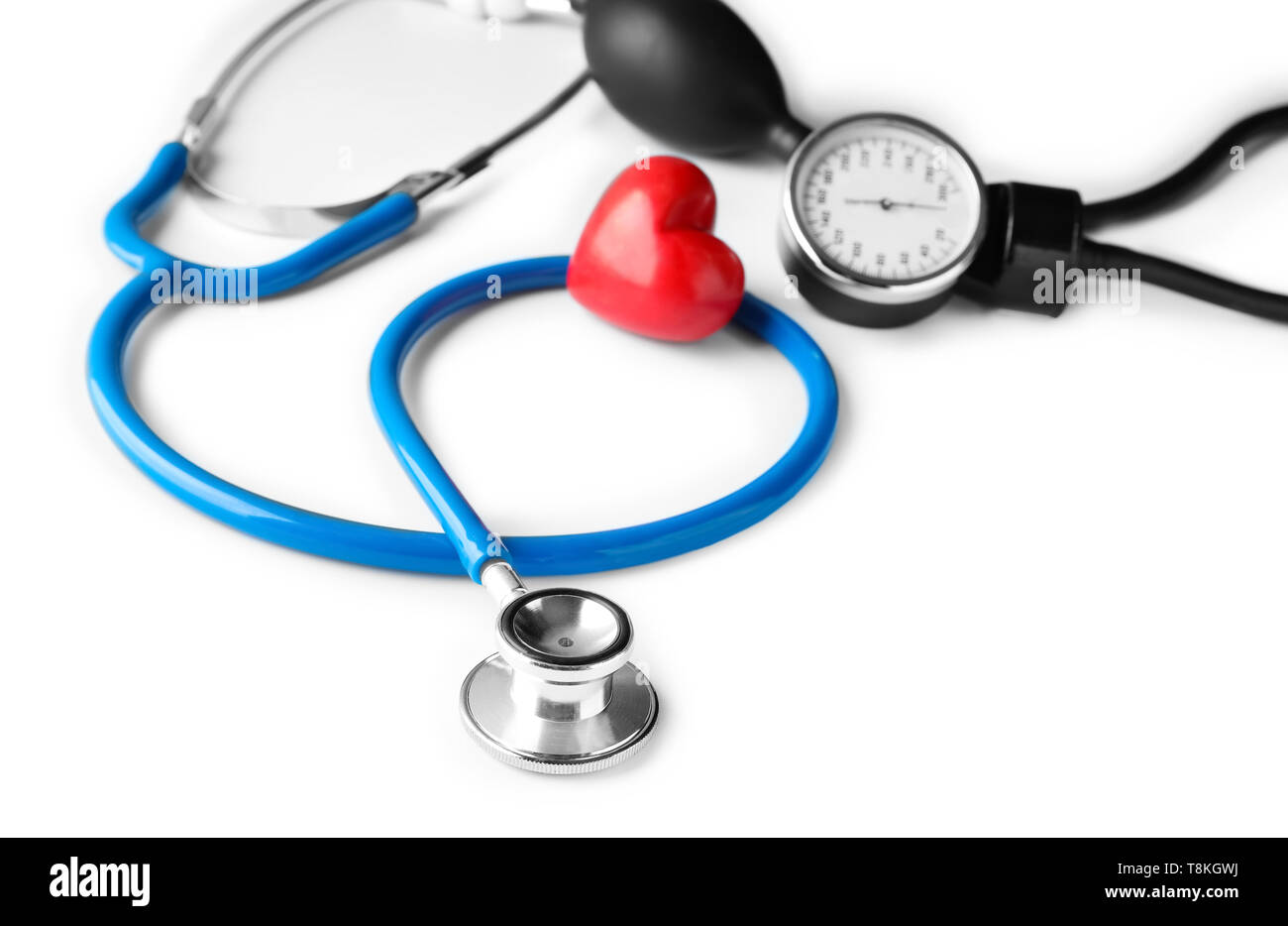 Medical stethoscope, sphygmomanometer and red heart on white background ...