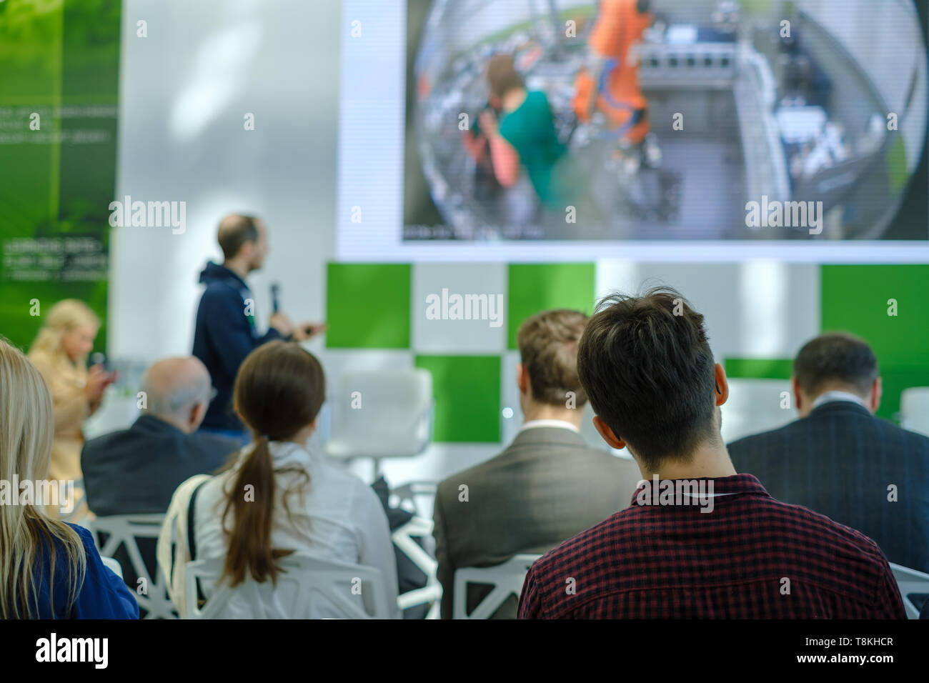 Audience listens to the lecturer at the business conference, back view ...